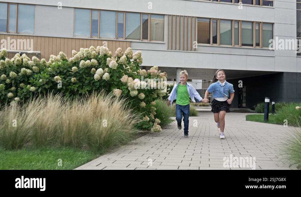 Two children, a boy and a girl of 8-9 years old, run around the school ...