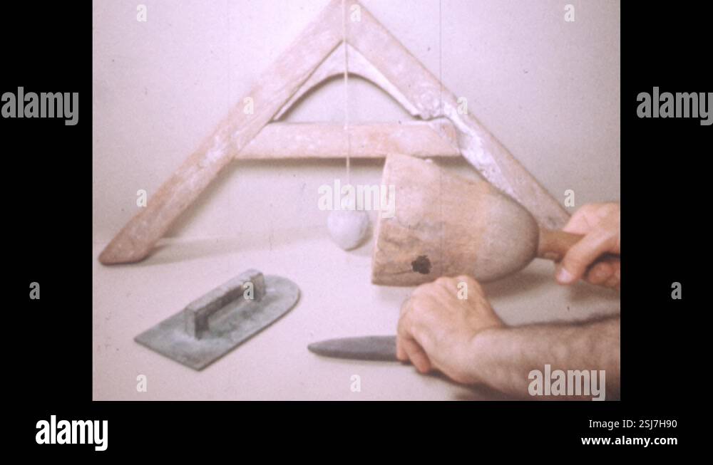 1950s: Primitive ancient tools. Hand uses wooden mallet to tap iron ...