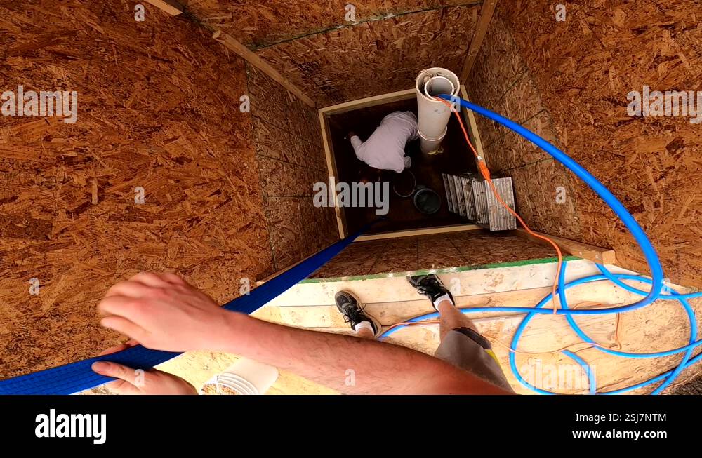 GH011417Lowering manual hand crank line and hook into home made well ...