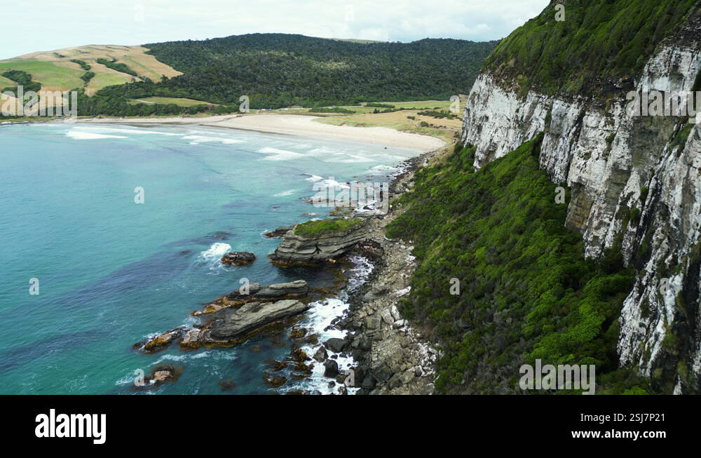 Aerial view of cliff revealing paradise beach at Parakaunui bay, New ...