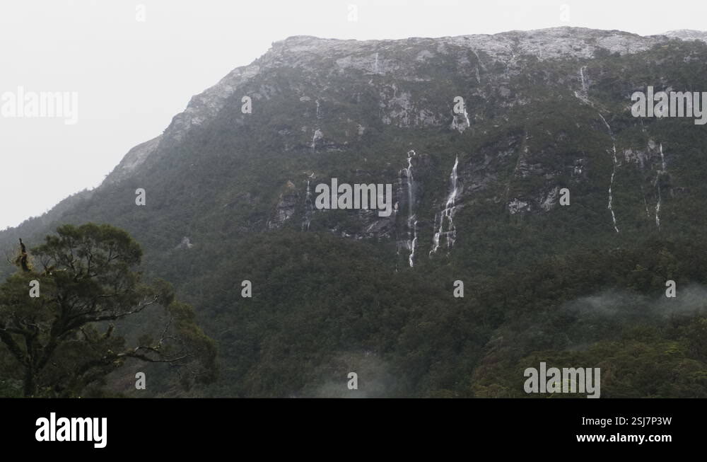A magnificent cliff face with multiple waterfalls cascading down during ...