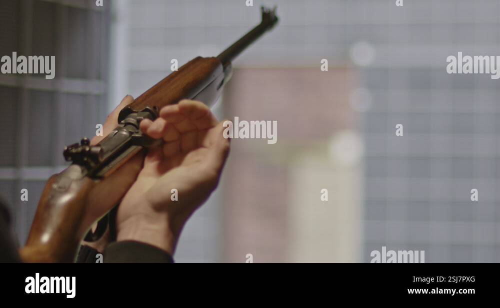 Shooter checking chamber of M1 carbine by sliding the bolt partially ...