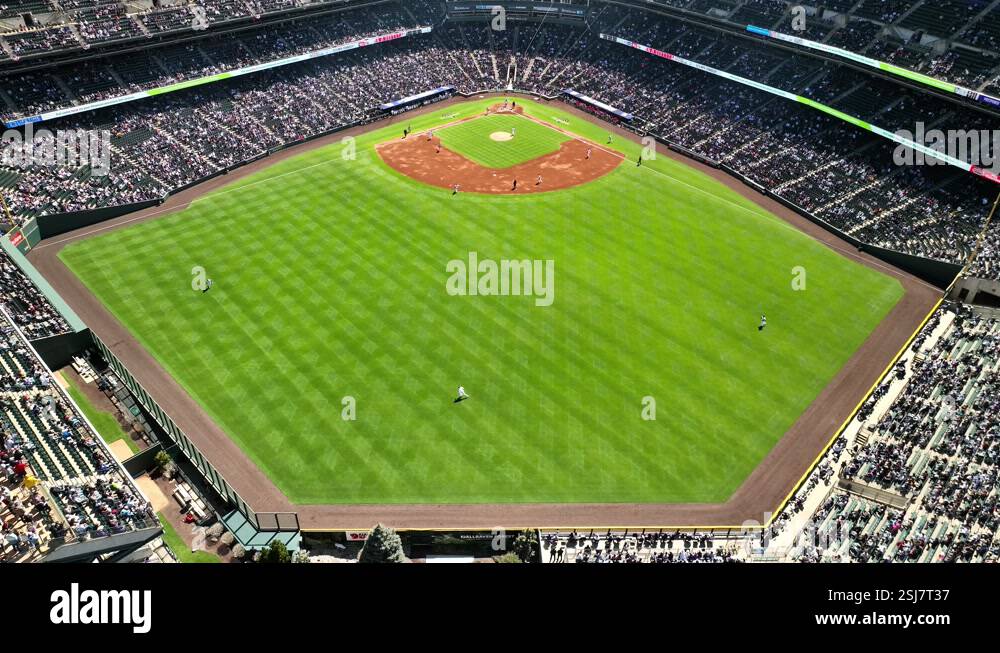 Drone view over baseball stadium of active game with crowds in stands ...