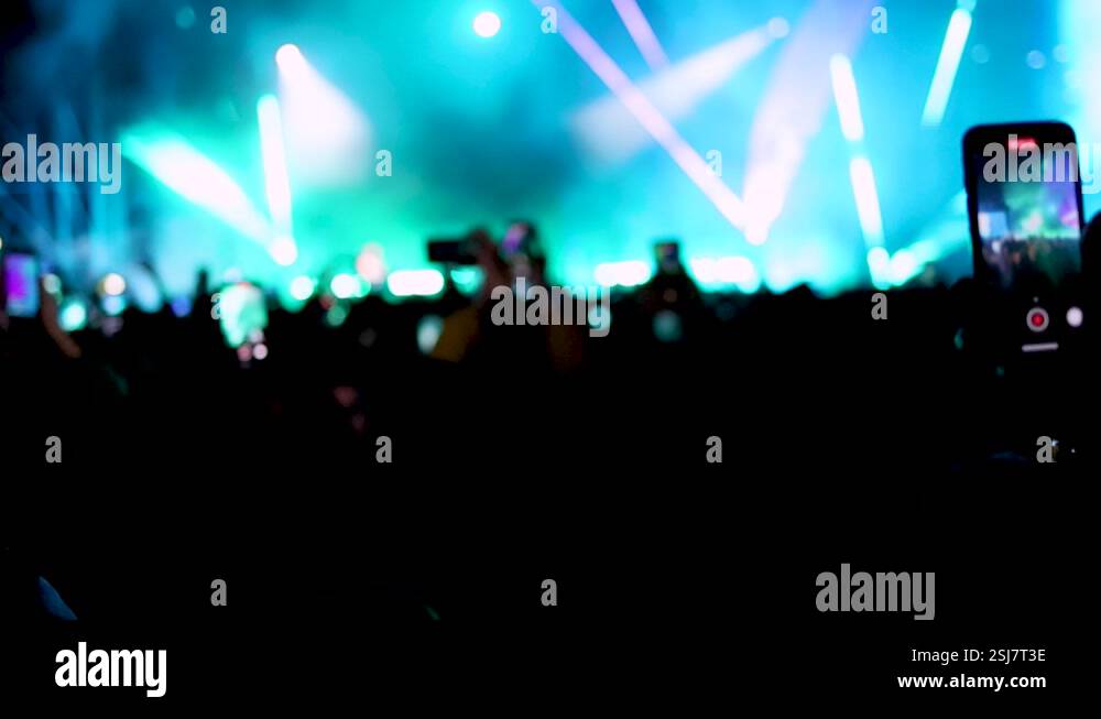Man in a crowd recording live show on stage with smartphone Stock Video ...