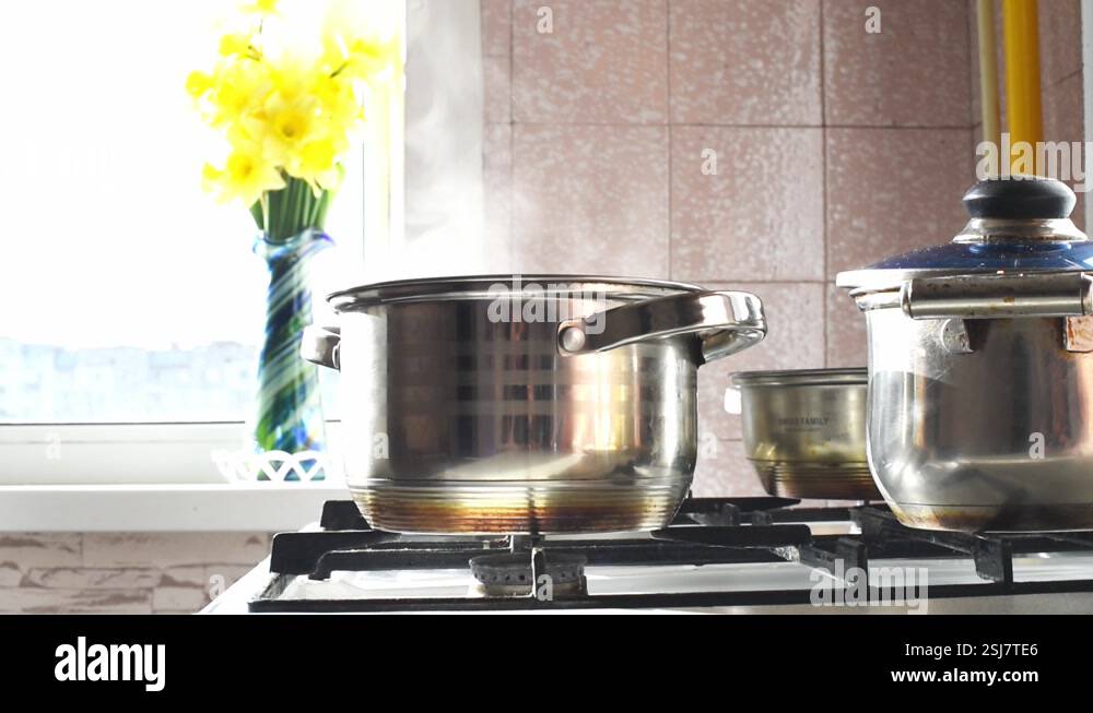 Boiling water in pot on gas cooker with steam, process of cooking. Cozy ...