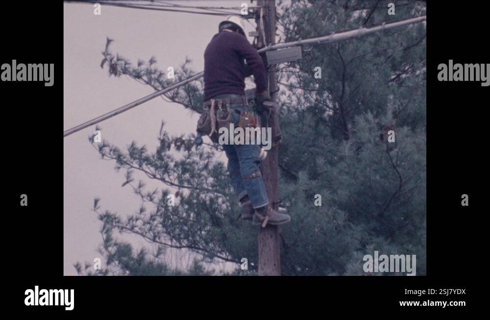1970s: Man works on telephone pole then climbs down when he's done ...