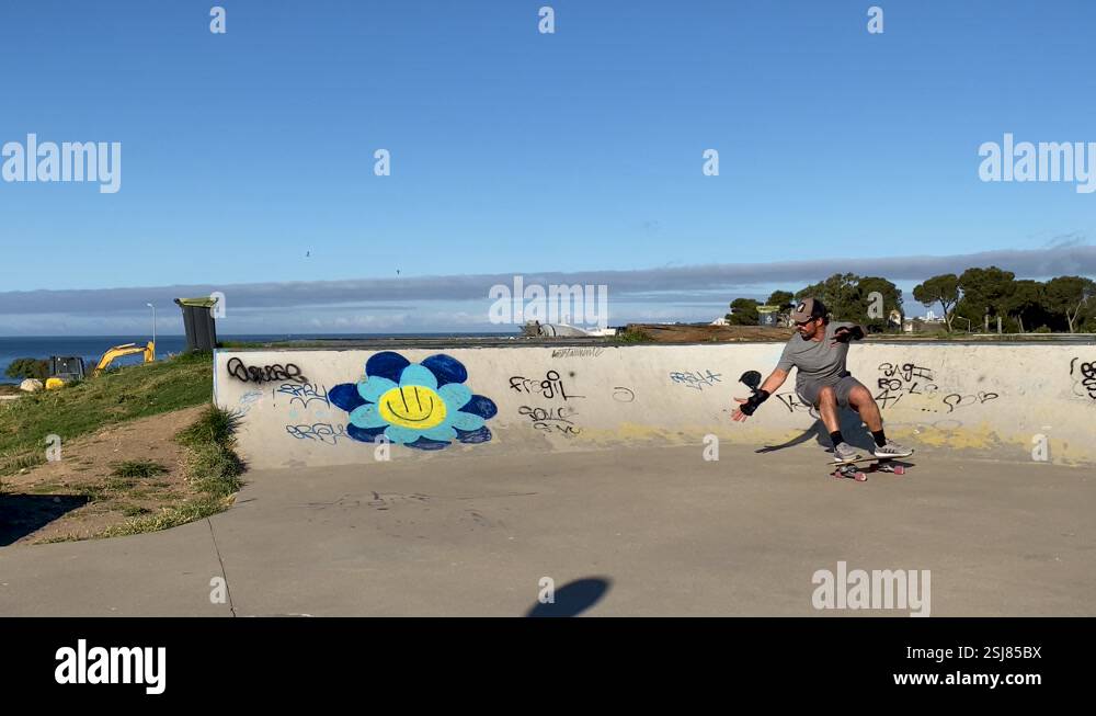 Static slow motion view of man carving up and down portugal skatepark ...