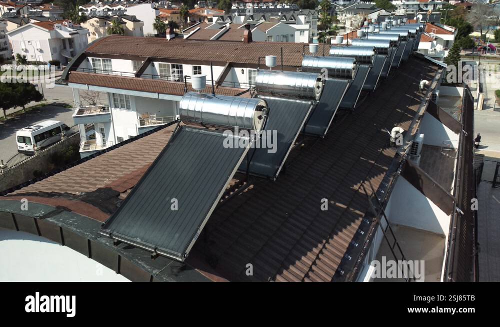 Aerial view water tanks and solar batteries on house roof, steel ...