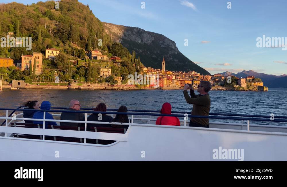 Tourists in ferry boat photographing Varenna picturesque Italian ...