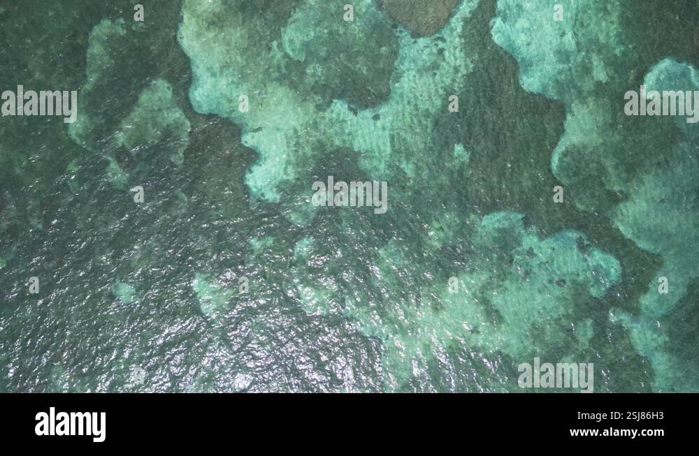 Top down aerial view of green ocean water over reef and sand bar by ...