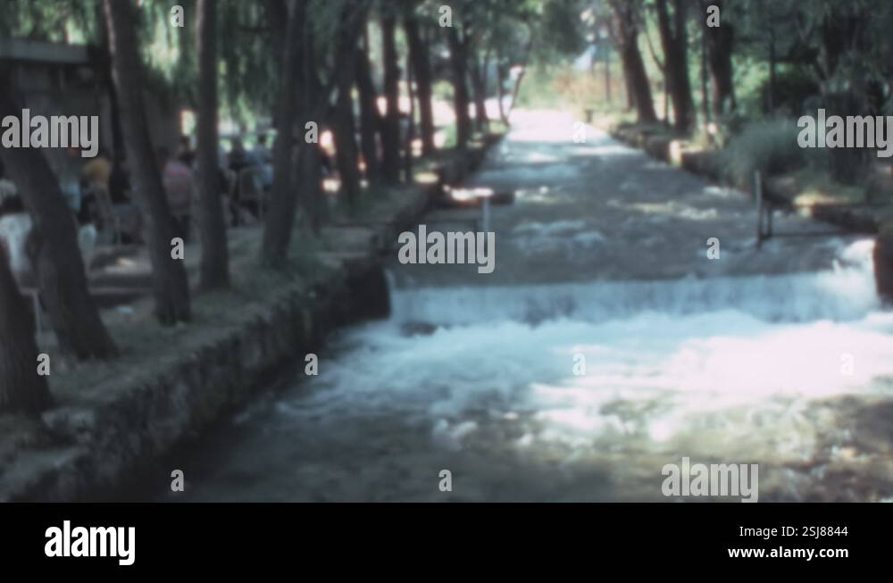 Flowing water in an artificial stream in a natural park. Relaxing ...