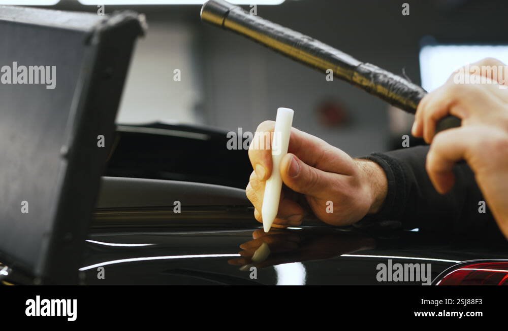 Using a hammer and a PDR tool to repair a dent on a car bodywork Stock ...