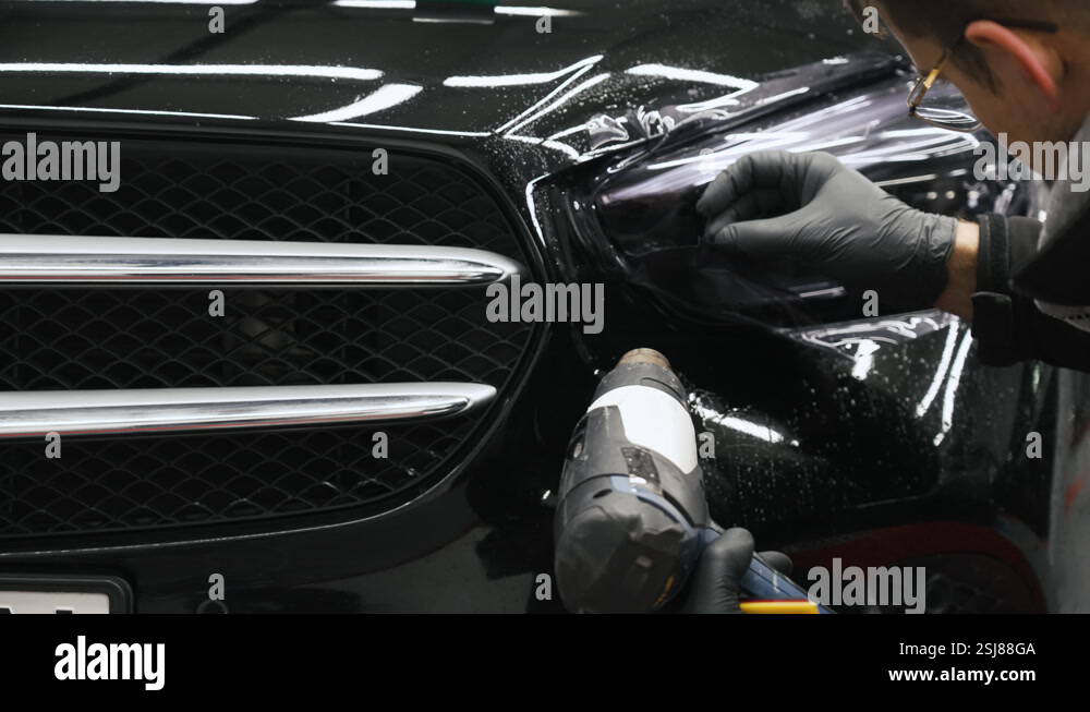 Using a hand welder to tint car headlights. Car detailing concept Stock ...