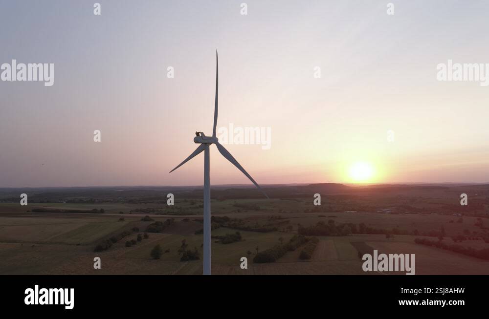 Aerial view of windmill spinning at sunset in European country ...