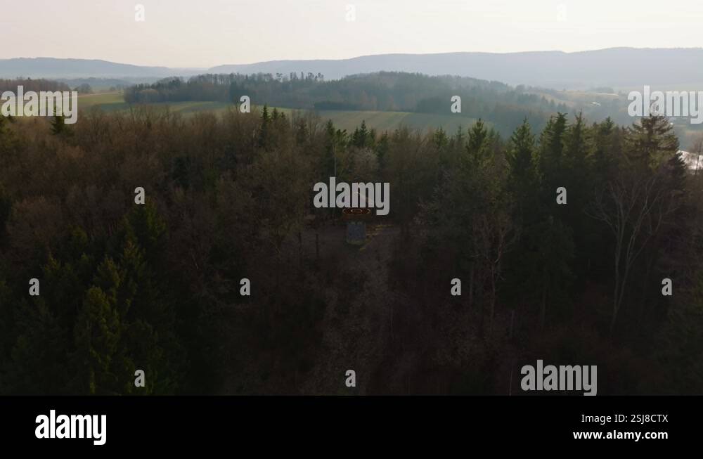Hláska lookout tower on a hill in the woods at a sunny sunset. A ...