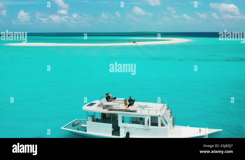 Family travels on a white boat near the sandbar to the Vaavu atoll ...