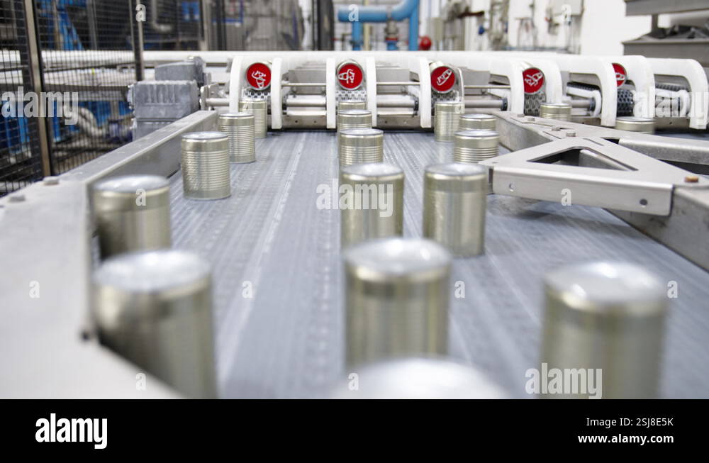 Green peas in cans on a conveyor belt in a canned food production ...
