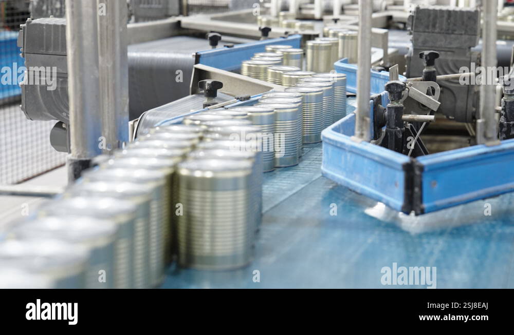 Green peas in cans on a conveyor belt in a canned food production ...