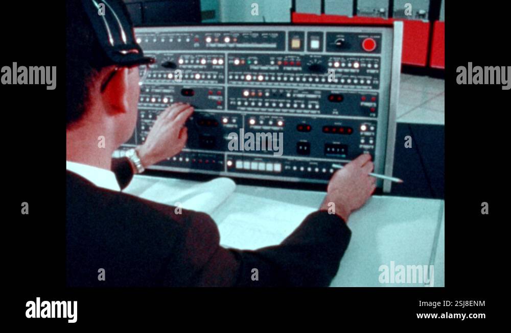1970s: Man at control panel. Tape reels moving. Punch cards in computer ...