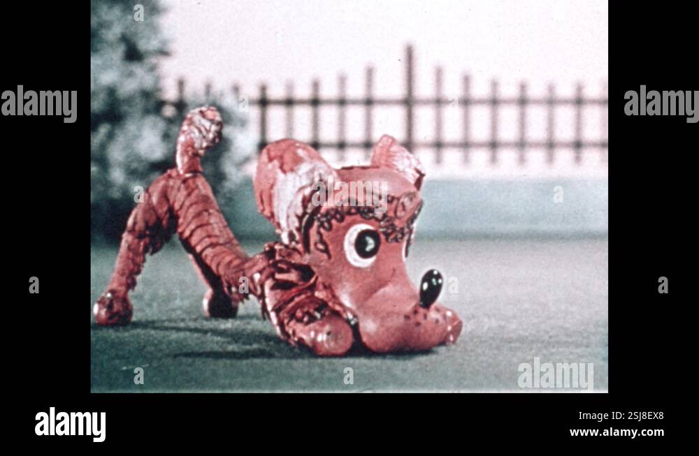 1970s: Stop motion duck sits in derby car. Back end of car is lifted up ...