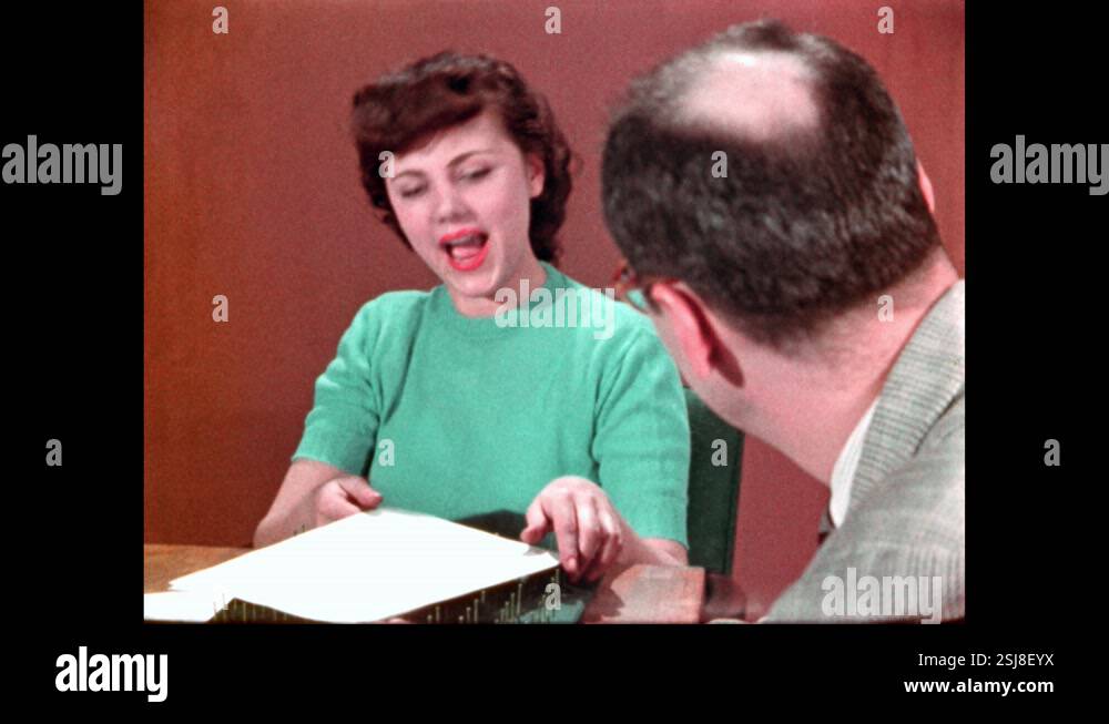 1950s: An aptitude test. A young woman looks at the test and hands it ...