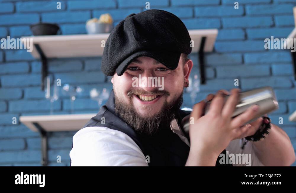 A classic authentic bartender with a smile and hat makes an alcoholic ...