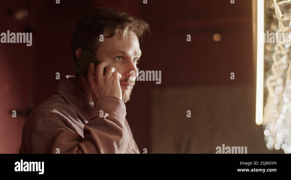 Male barkeeper talking on smartphone with client booking table Stock ...