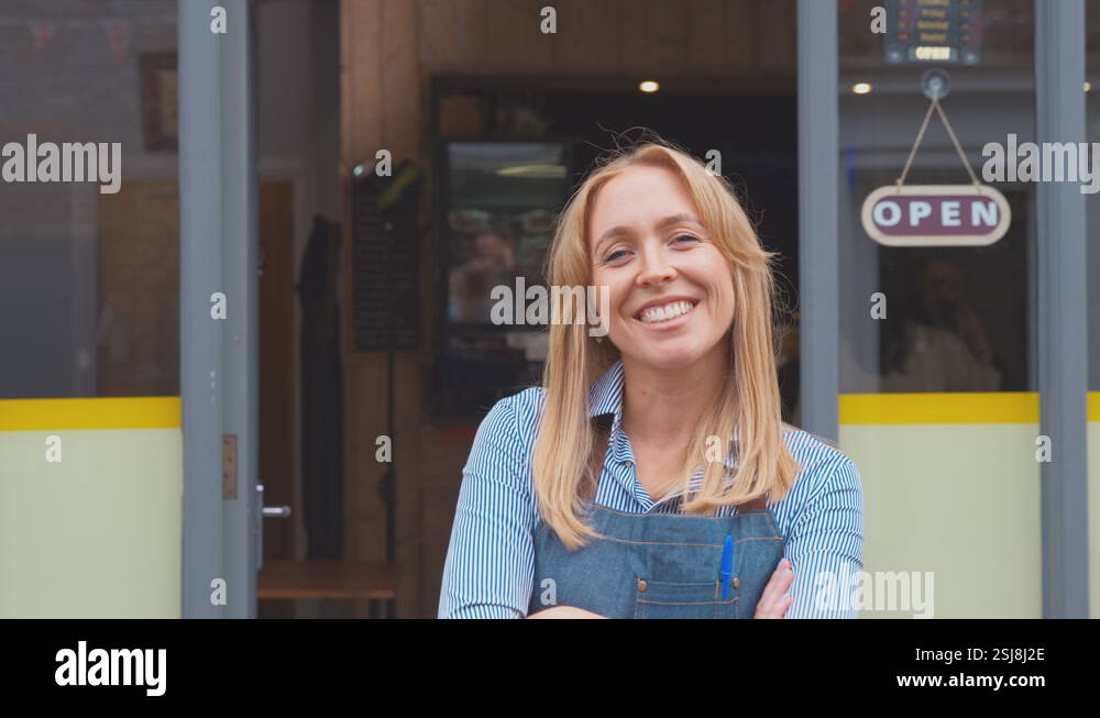 Portrait Of Female Owner Or Staff Outside Shop Or Cafe Standing By Open ...