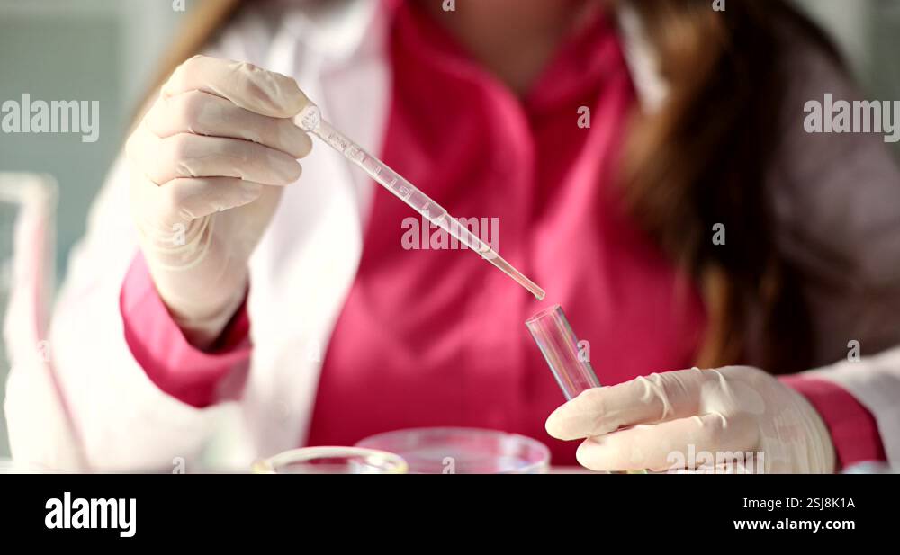 A woman in the laboratory is dripping a liquid in a flask Stock Video ...