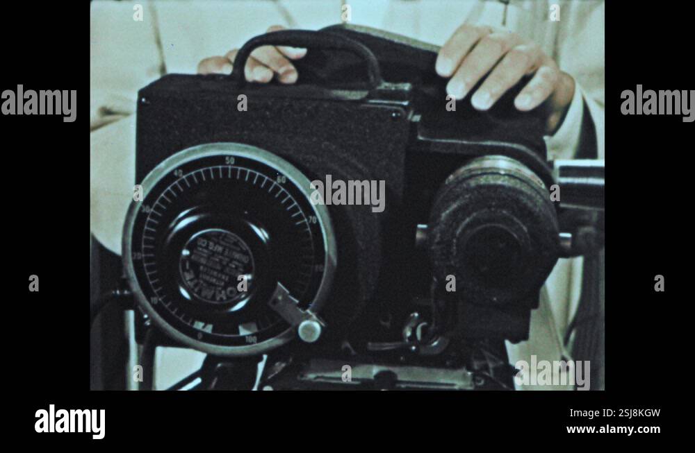 1950s: Hands touch high-speed camera. Men stand near cameras in lab and ...