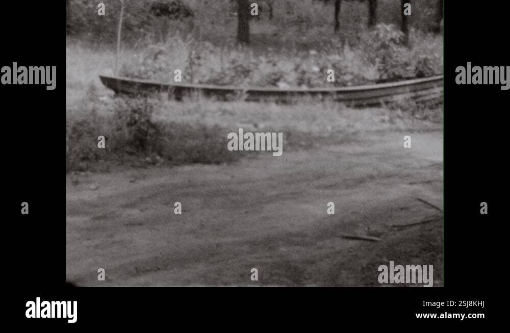 1930s: Woman, children shake objects. Men stand on lawn, wear hats ...