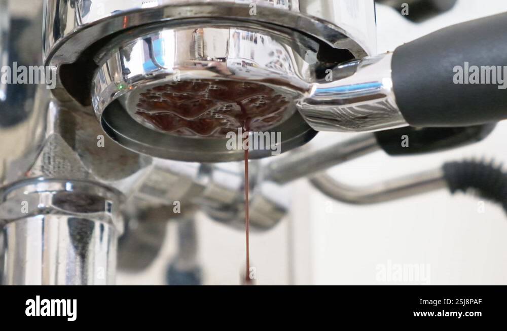 Espresso extracting and flowing out from a bottomless filter in slow ...
