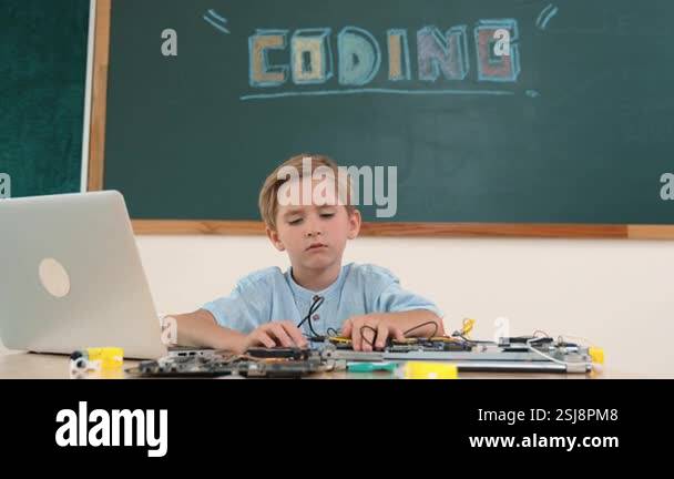 Student working on electronic board while sitting at Stem class with ...