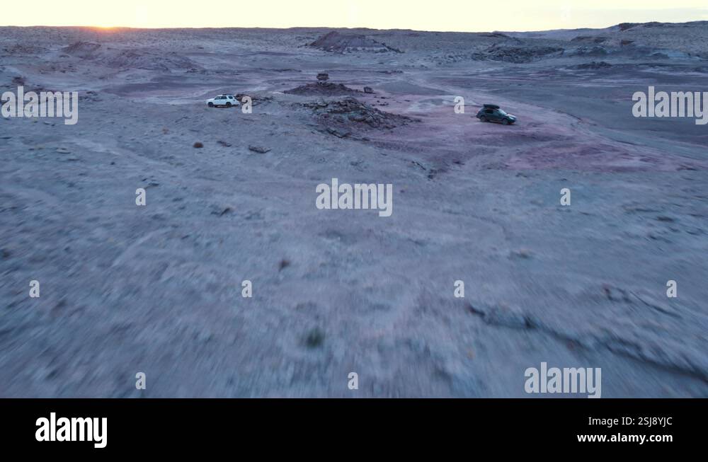 a convoy of overlanding vehicles car camping at blue hour sunset in ...
