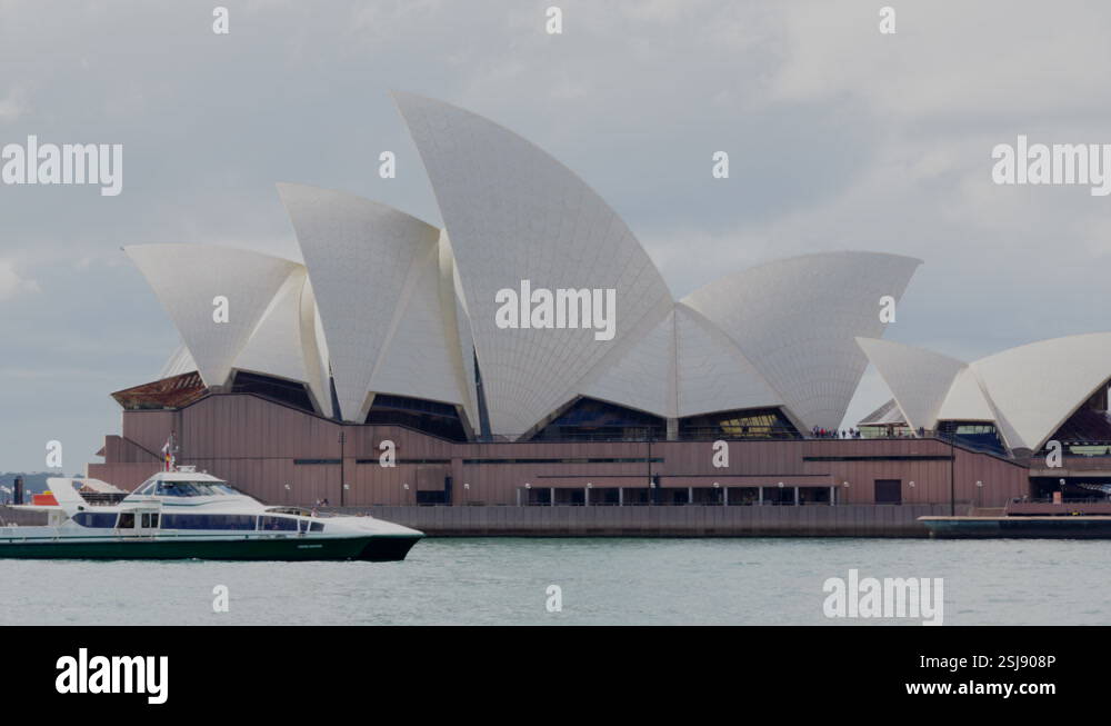 A slow moving ferry passes by the Sydney opera house, Australia Stock ...