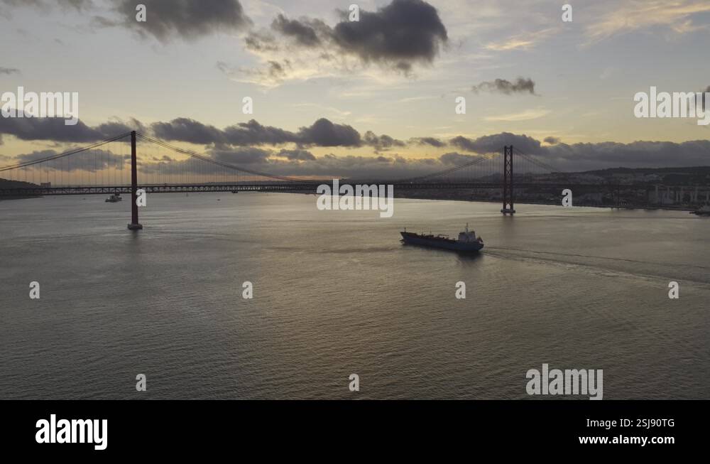 Drone shot rising and reversing away from a tanker ship heading under ...