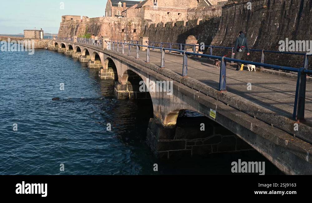 Bridge to Castle Cornet,St Peter Port Guernsey with dog walkers and ...