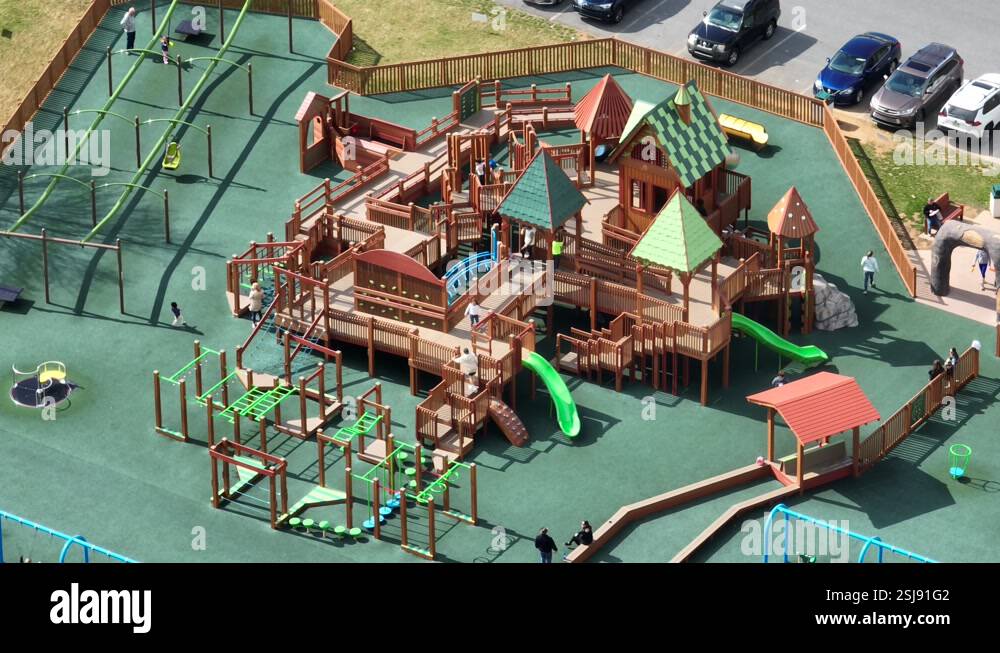 Children enjoy playground. Aerial view, long zoom. Unrecognizable kids ...