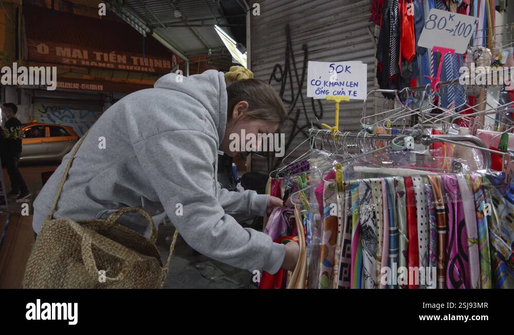 A woman browsing clothes on display at a night market in Ho Chi Minh ...