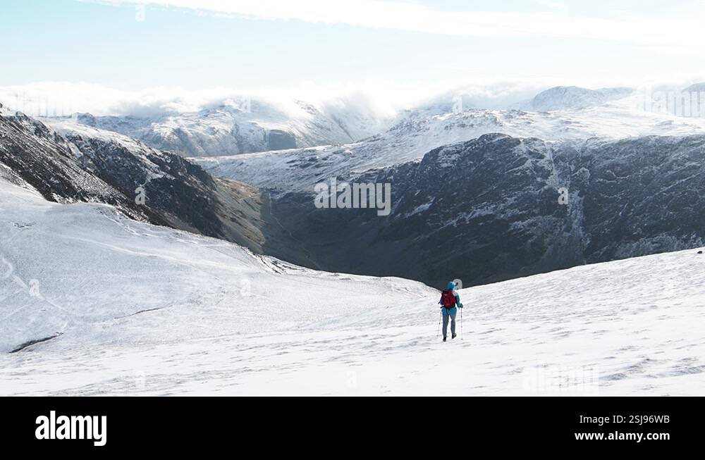 Cloud spilling over Glaramara with a woman hiker descending Robinson in ...