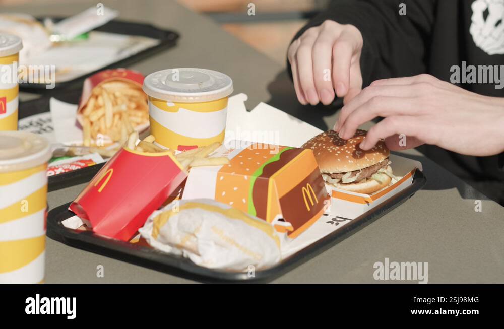 Teen boy eating Big Mac Menu with McDonalds logo box French fries, Cola ...