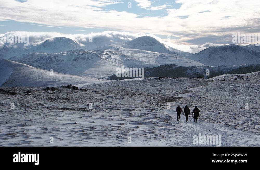 Cloud spilling over Great Gable and the Scafell range with walkers ...