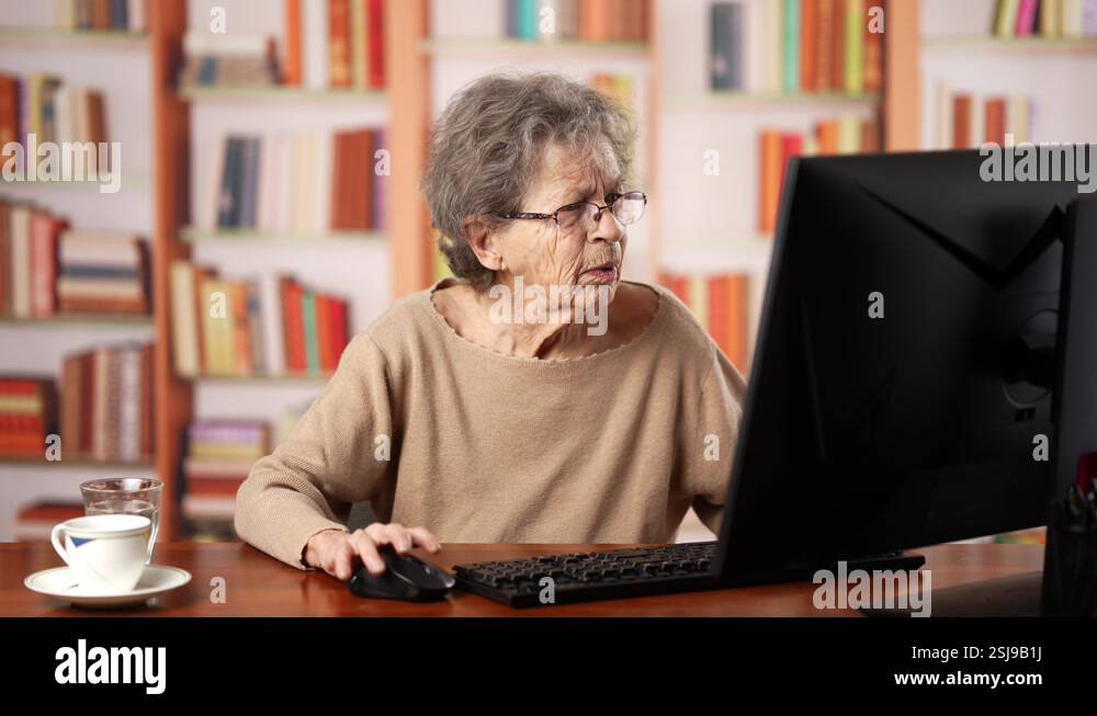 Angry stressed elderly old woman contemplates hitting computer with ...