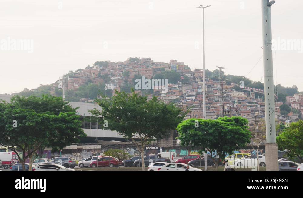 Wide shot of traffic on road in Rio de Janeiro with Favela Rocinha ...