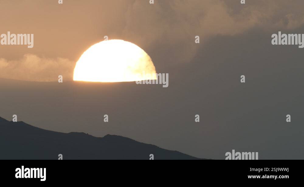 The sun setting over Ambleside, Lake District, UK with a hiker on a ...
