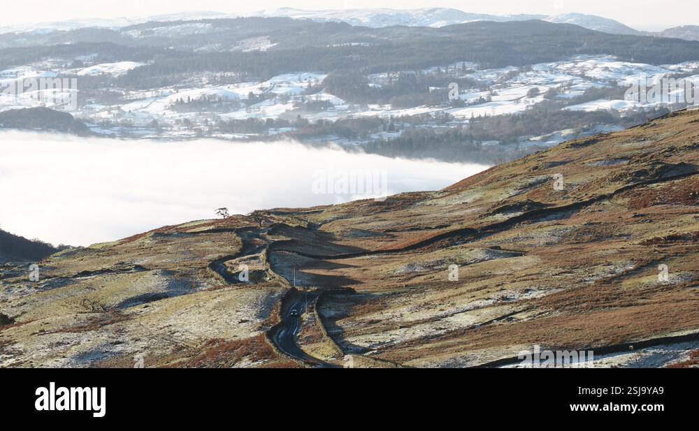 Cloud from a temperature inversion over Lake Windermere with a car ...