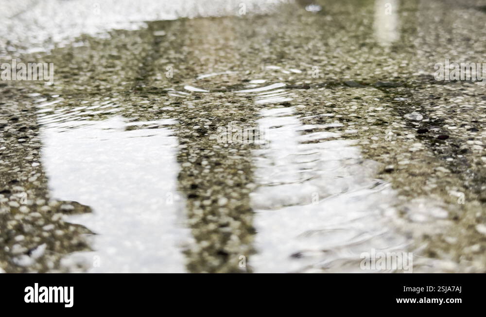 Super close-up of a puddle of water while it is raining. Daylight Stock ...
