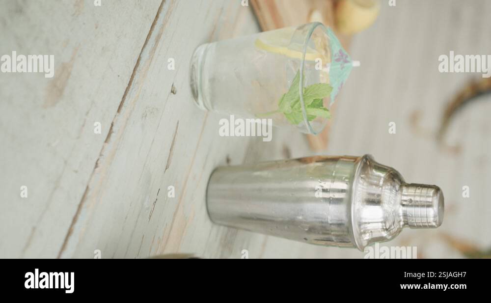 Vertical video of cocktail, cocktail shaker and ingredients on bar at ...