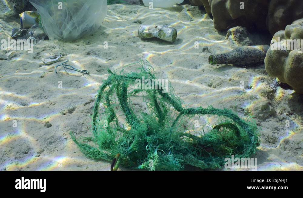 Closeup, Plastic pollution on beautiful shallow coral reef, Slow motion ...