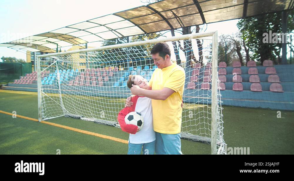 Father and Son play football on stadium, family outdoors, bonding, fun ...